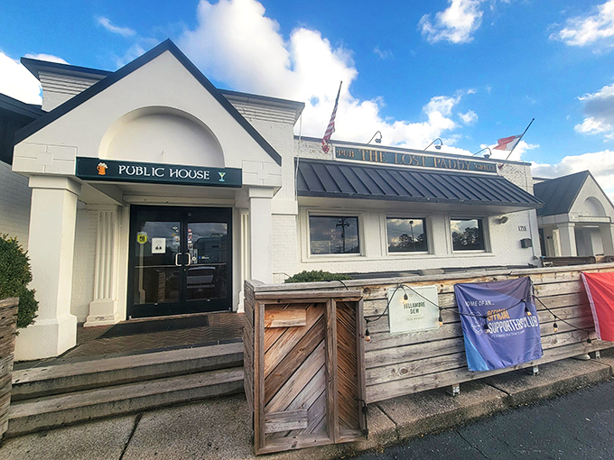The white facade with its distinctive black awning promises Irish hospitality with a Nashville twist. Soccer flags flutter in welcome.