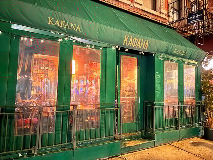 As evening falls, Kafana's emerald exterior glows with warm light, transforming this East Village corner into a slice of Belgrade.