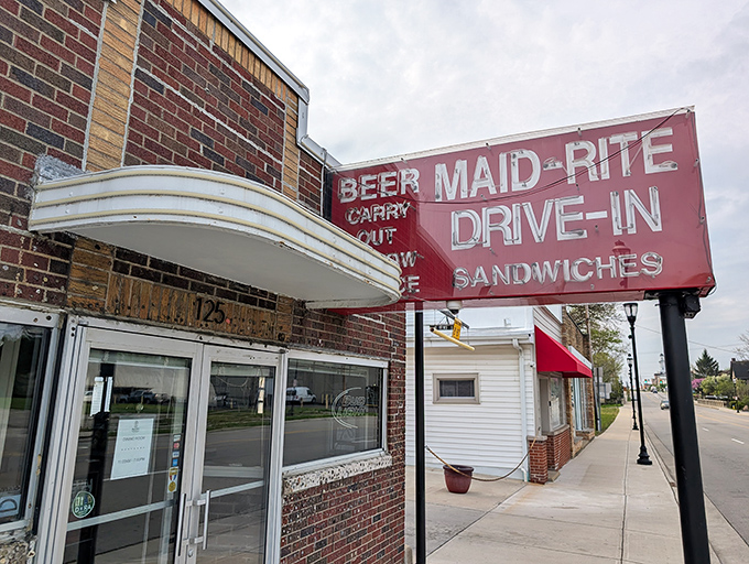 The vintage neon sign of Maid-Rite glows like a beacon for hungry travelers—a Midwestern lighthouse guiding you home.