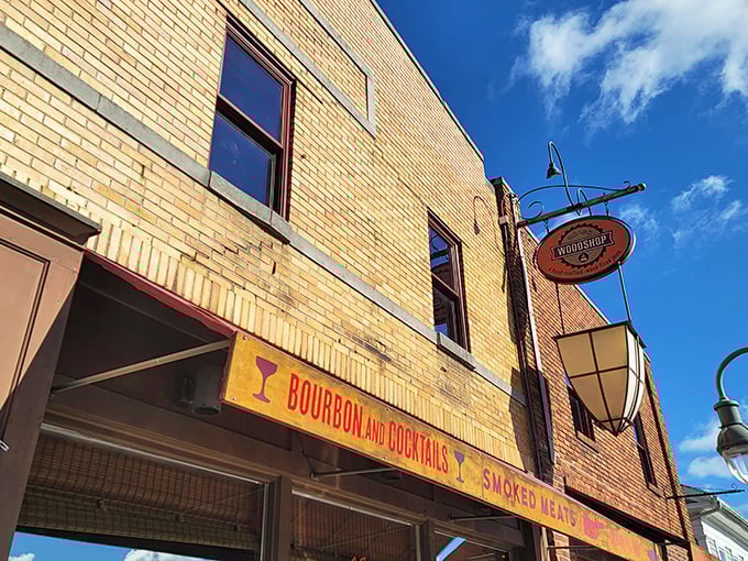 The golden brick facade of Union Woodshop beckons like a barbecue lighthouse on Main Street, promising smoky treasures within. "Bourbon and Cocktails" isn't just signage—it's a lifestyle statement.
