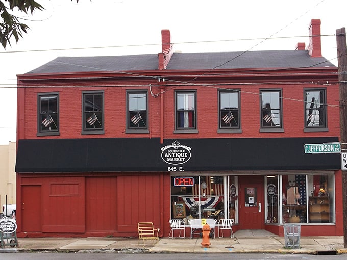 The brick-red façade of Louisville Antique Market stands like a time portal on Jefferson Street, American flags hinting at the historical treasures within.