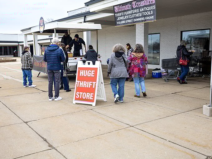 The unassuming storefront promises "HUGE THRIFT STORE" – a rare case where retail underselling meets reality. Treasure hunters gather outside, drawn by the siren call of bargains.