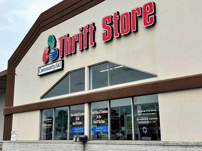 The bright trio of hands on CommunityAid’s façade isn’t just a logo—it’s a friendly wave inviting you to a thrift-store treasure hunt inside.