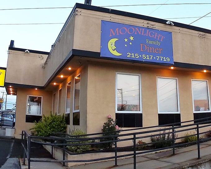 The iconic blue sign of Moonlight Diner glows with promise against the tan exterior—a beacon of comfort food in Glenside's landscape.