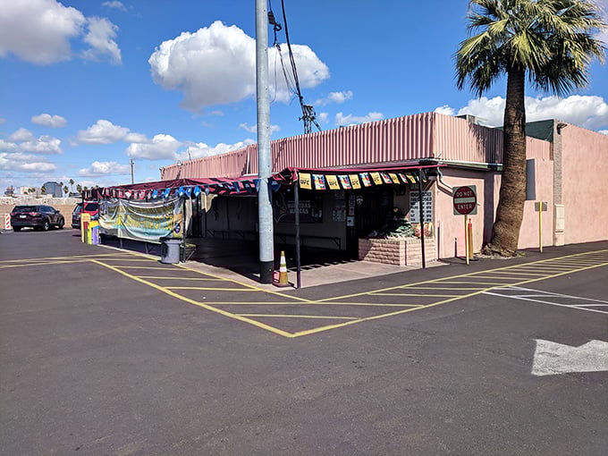 Another view reveals the restaurant's pink facade and striped awning—architectural appetizers before the main course of flavors waiting inside.