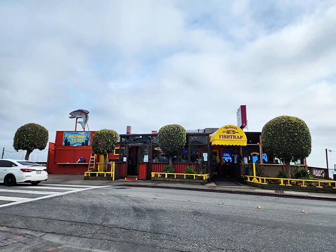 The bright yellow awning and weathered red exterior of Barbara's Fishtrap stands as a beacon for seafood lovers—no Instagram filters required for this authentic coastal gem.