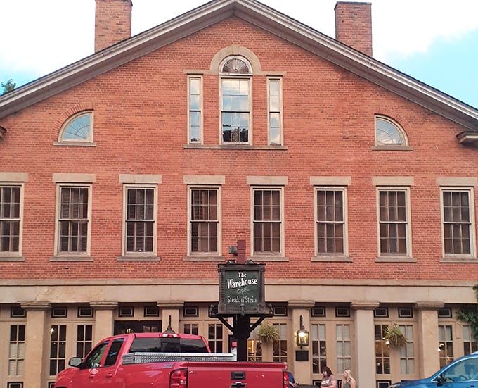The historic brick façade of The Warehouse Restaurant stands proudly in Coshocton, where a rainbow occasionally appears as if to highlight this culinary treasure.