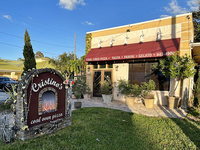 The charming exterior of Cristino's beckons with its burgundy awnings and lush greenery—a little slice of Italy hiding in plain sight in Clearwater.