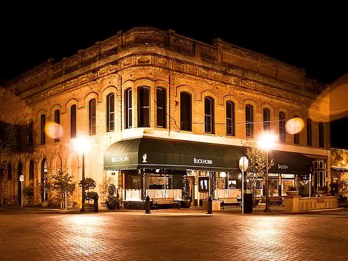 The historic brick facade of Buckhorn Steakhouse glows at night, promising carnivorous delights within this Winters landmark that’s been drawing meat lovers for generations.