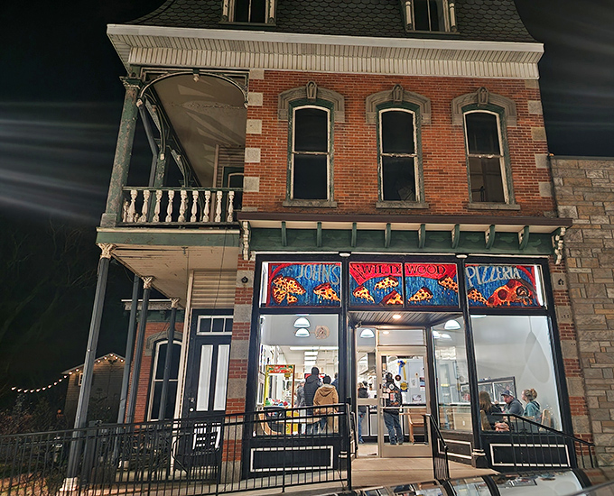 The historic brick façade of John's Wildwood Pizzeria glows like a beacon in the night, promising comfort food that transcends its humble appearance.