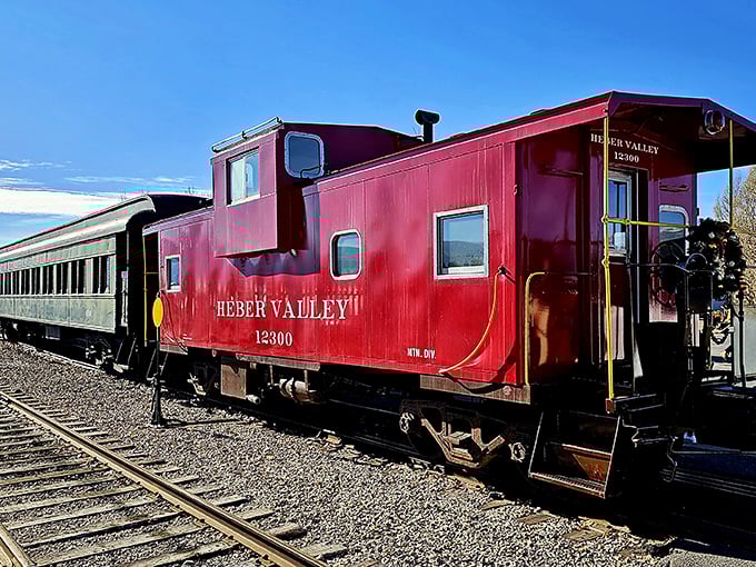 The iconic red caboose of the Heber Valley Railroad stands ready for adventure, a crimson time capsule against Utah's blue skies.