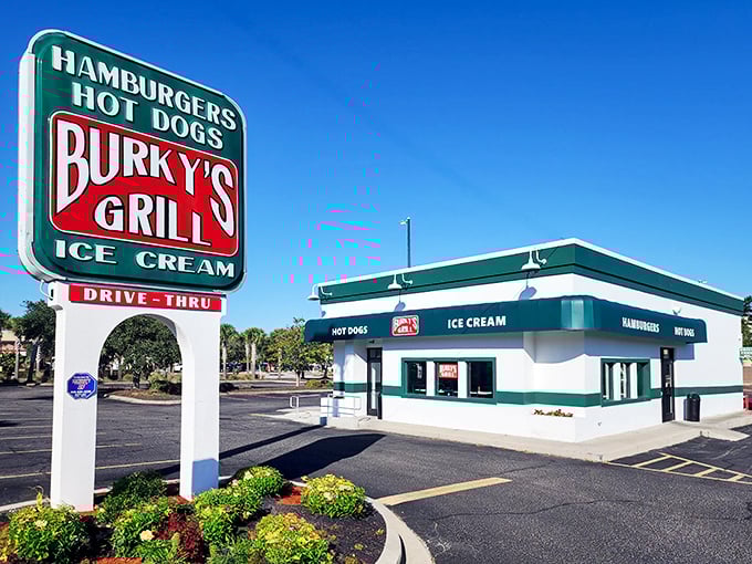 The iconic green and white Burky's sign stands like a beacon of hope for hungry travelers—promising simple pleasures executed with surprising perfection.