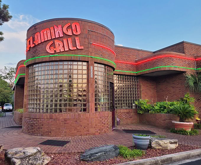 The curved glass block entrance of Flamingo Grill isn't just retro-cool architecture—it's a time portal to when dining out was an event worth dressing up for.