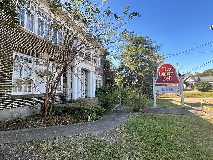 The Dinner Bell's stately brick exterior and white columns aren't just Southern charm – they're the gateway to a fried chicken paradise hiding in plain sight.