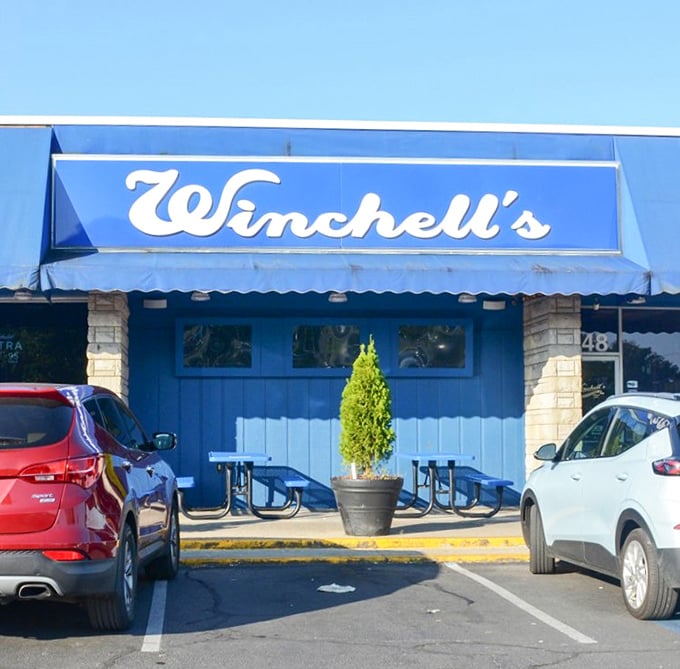 That signature Winchell's blue continues right to the entrance, where a touch of greenery welcomes diners. The picnic tables hint at casual comfort—exactly what you want before diving into that famous buffalo chicken sandwich.
