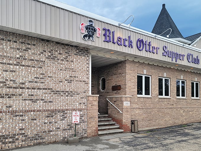 The purple signage of Black Otter Supper Club glows against the brick exterior like a beacon for hungry travelers—Wisconsin's version of the North Star.