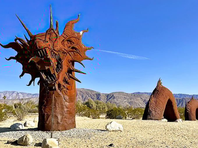 A fearsome sea dragon emerges from the desert floor, its rusty scales glinting in the California sunshine against a backdrop of distant mountains.