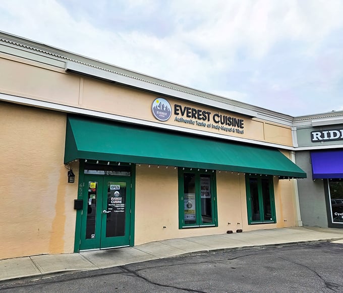 The unassuming exterior of Everest Cuisine belies the flavor explosion waiting inside. That green awning might as well be a portal to Kathmandu.