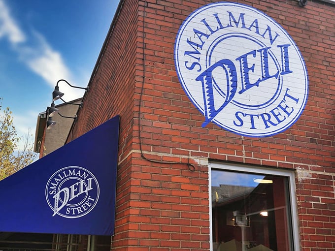 The iconic blue awning and brick facade of Smallman Street Deli stands as a beacon of sandwich salvation in Pittsburgh's Strip District.