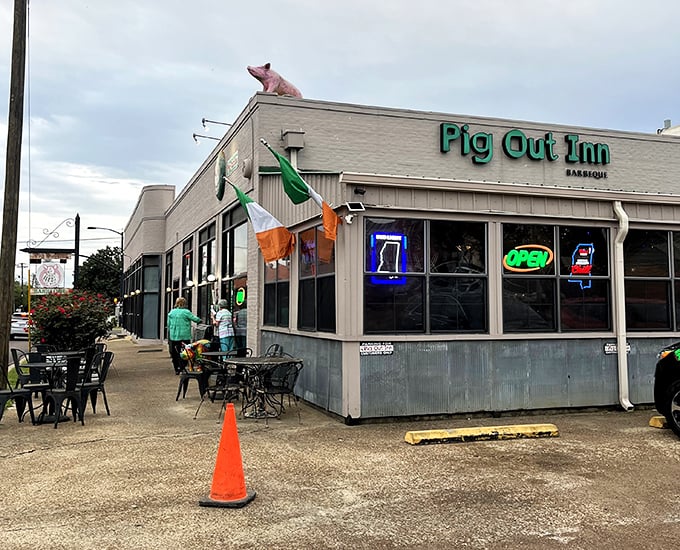 Where flags flutter and neon glows, this unassuming barbecue sanctuary proves that the most memorable meals often hide behind the most modest facades.