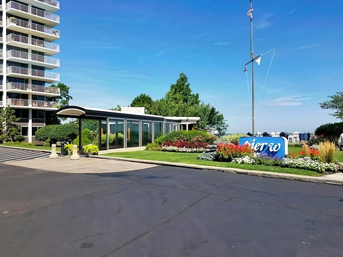 Pier W's entrance welcomes you like a maritime embrace, with vibrant flowers standing guard beside that iconic blue sign. Lake Erie's best-dressed restaurant awaits.