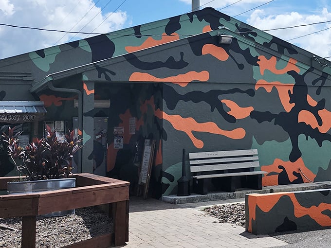 Military-inspired camouflage isn't hiding anything here—this tavern wants to be found. The outdoor bench invites you to take a breather before the flavor assault begins.