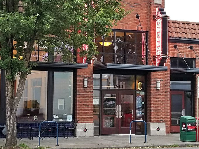 The brick exterior of Cadillac Café stands like a culinary lighthouse on Northeast Broadway, beckoning hungry souls with its vintage neon sign.