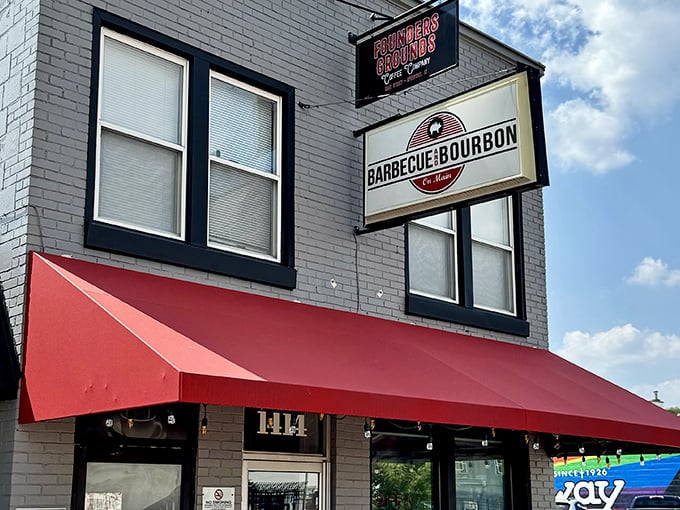 The bright red awning against the gray brick facade isn't just eye-catching—it's a beacon for barbecue pilgrims seeking smoky salvation in Speedway.