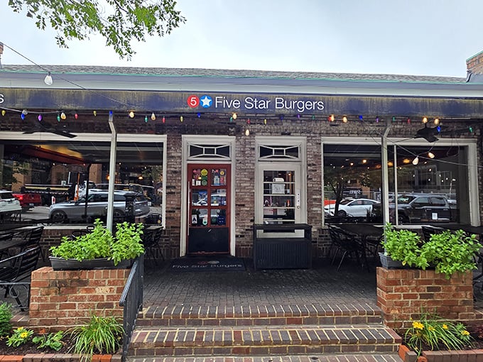 The charming brick exterior of 5 Star Burgers welcomes you with string lights and lush planters—like that friend whose house always feels more inviting than yours.