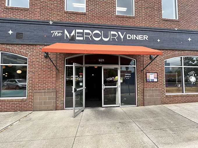 The Mercury Diner's brick facade with its distinctive navy blue signage and orange awning beckons like a retro-futuristic beacon on Columbus's streetscape.