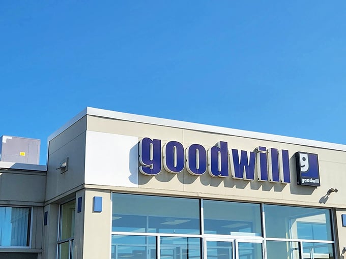 The iconic blue Goodwill sign against a clear sky – retail therapy with a conscience and prices that'll make your wallet smile.