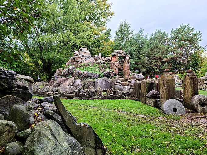 The centerpiece of this backyard wonderland rises like a miniature mountain range, complete with stone pillars that seem to defy both gravity and conventional landscaping wisdom.
