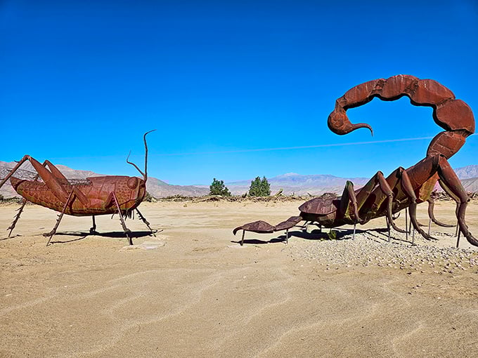 In the heart of the California desert, a giant scorpion faces off against a towering grasshopper — a surreal standoff frozen in rust and sunlight.