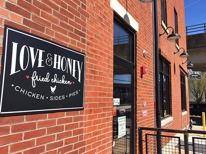 The iconic black and white sign against red brick announces Love & Honey's presence without fanfare—like all great food destinations, the flavors do the talking.