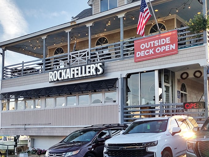 The coastal charm of Rockafeller's exterior beckons with its wraparound deck and American flag fluttering above—a siren call to seafood lovers everywhere.