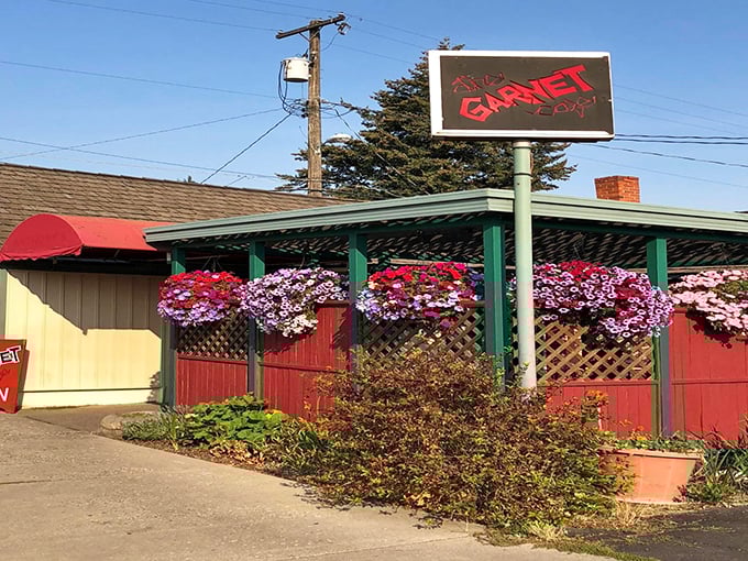 The Garnet Cafe's exterior blooms with hanging flower baskets, a colorful welcome that hints at the vibrant flavors waiting inside this unassuming breakfast paradise.