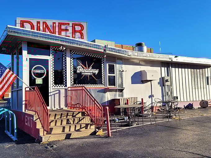 Classic Americana at its finest—red steps leading to breakfast paradise, with the Stars and Stripes standing proud beside Broadway Diner's iconic facade.