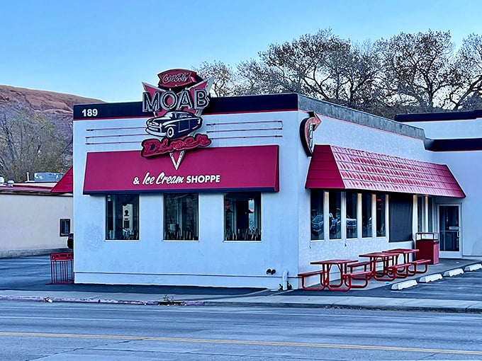 The classic red and white exterior of Moab Diner stands like a time capsule against Utah's blue sky, promising comfort food salvation after a day of desert adventures.