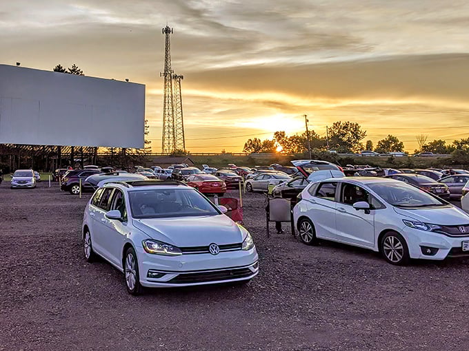Cars line up at dusk, their headlights dimming as the massive screen awaits. Modern vehicles, vintage experience—the perfect pairing for movie magic.