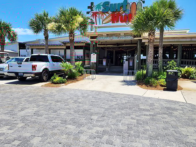 The Surf Hut's entrance beckons like a tropical mirage after a long beach day, promising seafood salvation under those swaying palms.