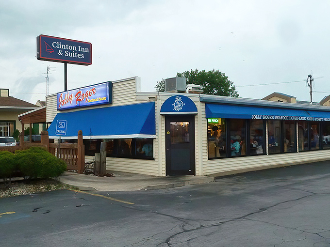 The blue awnings of Jolly Rogers beckon like a maritime oasis in Port Clinton, promising seafood treasures within its unassuming exterior.