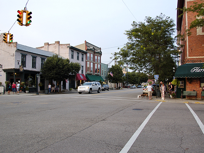 Main Street magic in full display – historic storefronts, vintage lampposts, and locals gathering on benches create the quintessential small-town tableau.