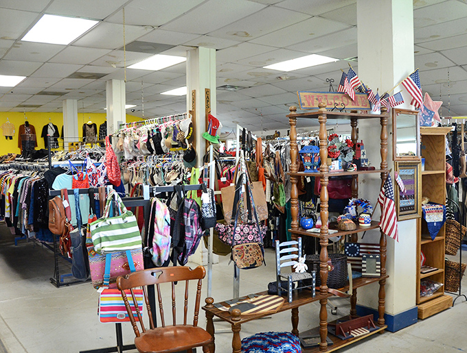 Inside Encore Thrift Store, racks of clothes, quirky finds, and assorted treasures fill the space, with American flags hanging overhead, welcoming bargain hunters to explore every corner.