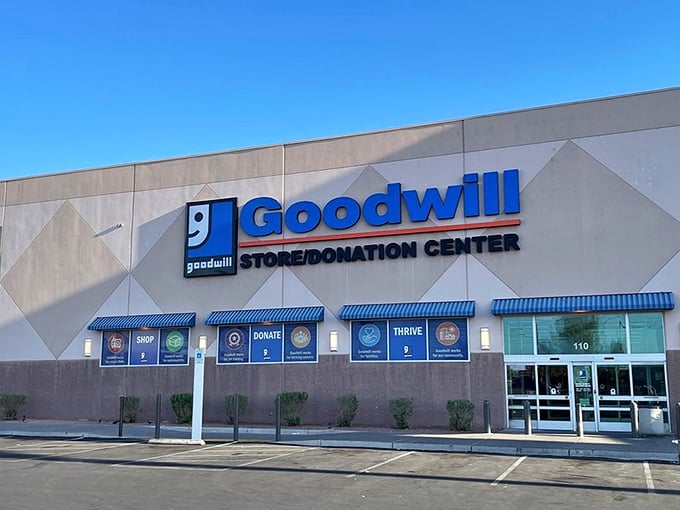 The iconic blue Goodwill sign beckons bargain hunters like a desert oasis promising treasures instead of water.