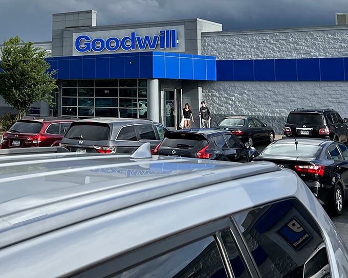 The blue-trimmed facade of Goodwill on Woodruff Road stands like a retail Narnia—ordinary on the outside, magical treasures within.