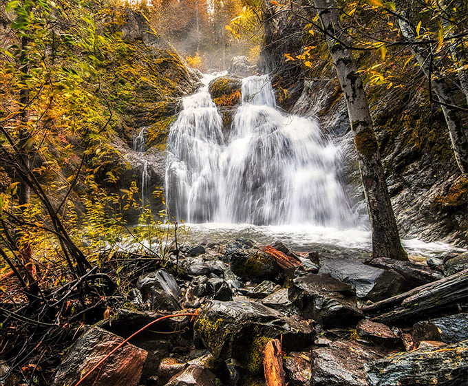 Nature's perfect cascade – Faery Falls tumbles 50 feet over moss-covered rocks, creating a crystal-clear pool that practically begs for a brave toe-dip.