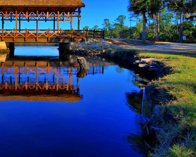 The bridge's perfect reflection creates a mirror image so flawless you'll wonder which side is real and which is the dream.