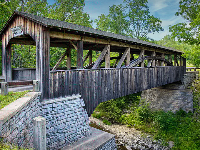 Sunlight dances across the bridge's timbers on a perfect summer day, showcasing the craftsmanship that's outlasted countless modern structures.