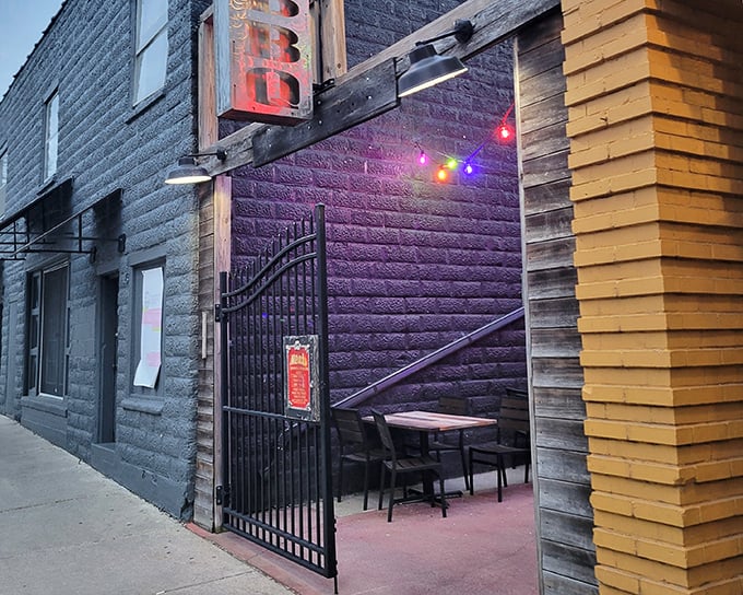 The unassuming entrance to Meat BBQ beckons like a secret clubhouse for carnivores. String lights and green umbrellas add a touch of backyard charm.