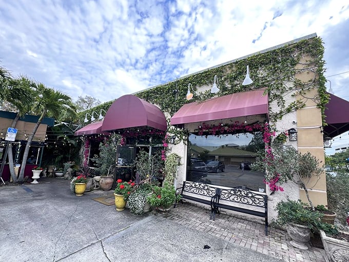 The charming exterior of Cristino's beckons with its burgundy awnings and lush greenery—a little slice of Italy hiding in plain sight in Clearwater.